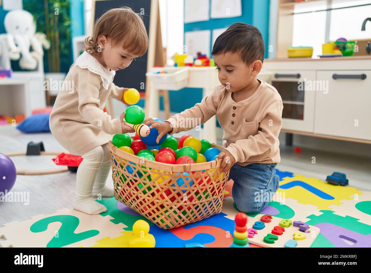 Two kids playing with balls standing at kindergarten Stock Photo - Alamy