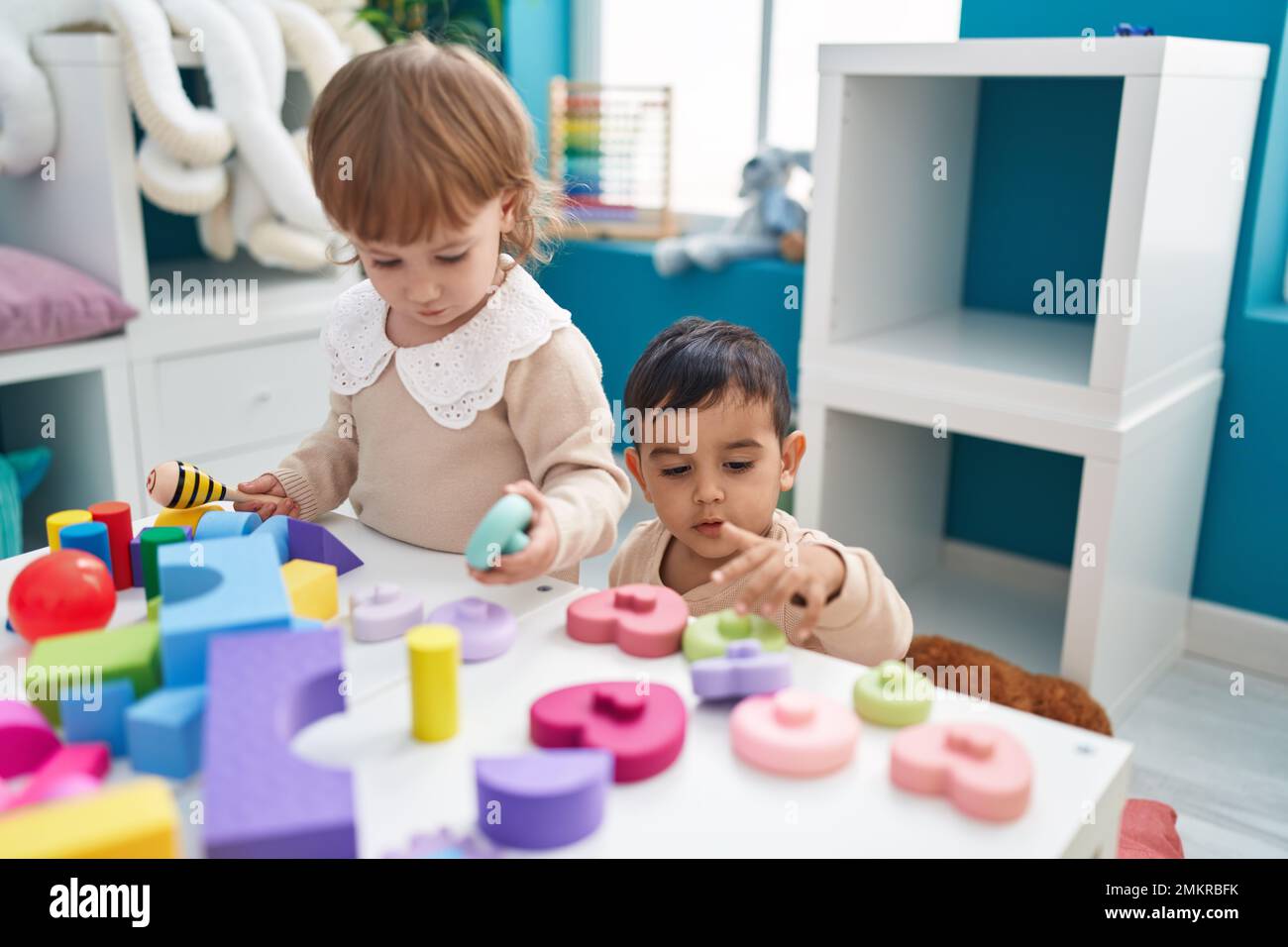 Two kids playing with construction blocks standing at kindergarten ...