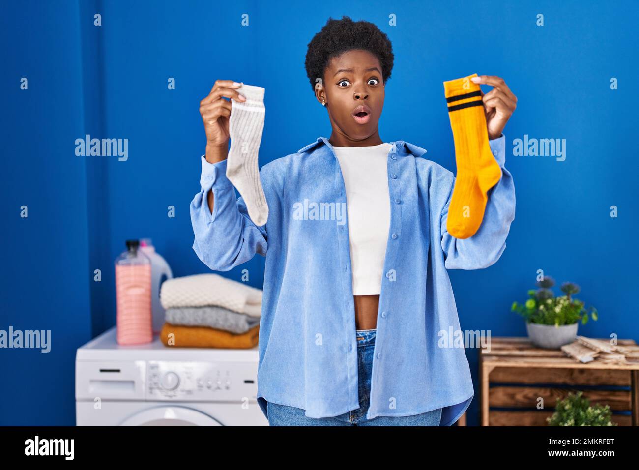 African american woman holding clean andy dirty socks in shock face ...