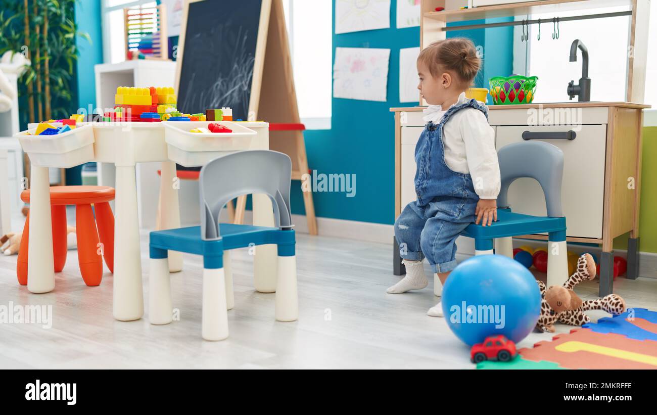 Adorable blonde toddler smiling confident sitting on chair at kindergarten Stock Photo - Alamy
