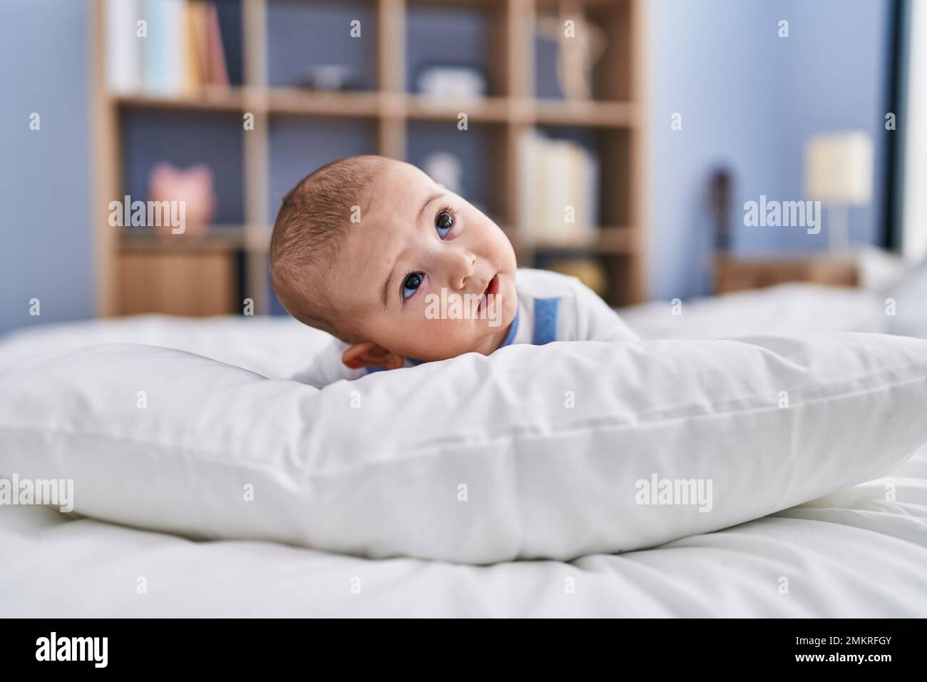 Adorable baby relaxed lying on bed at bedroom Stock Photo - Alamy