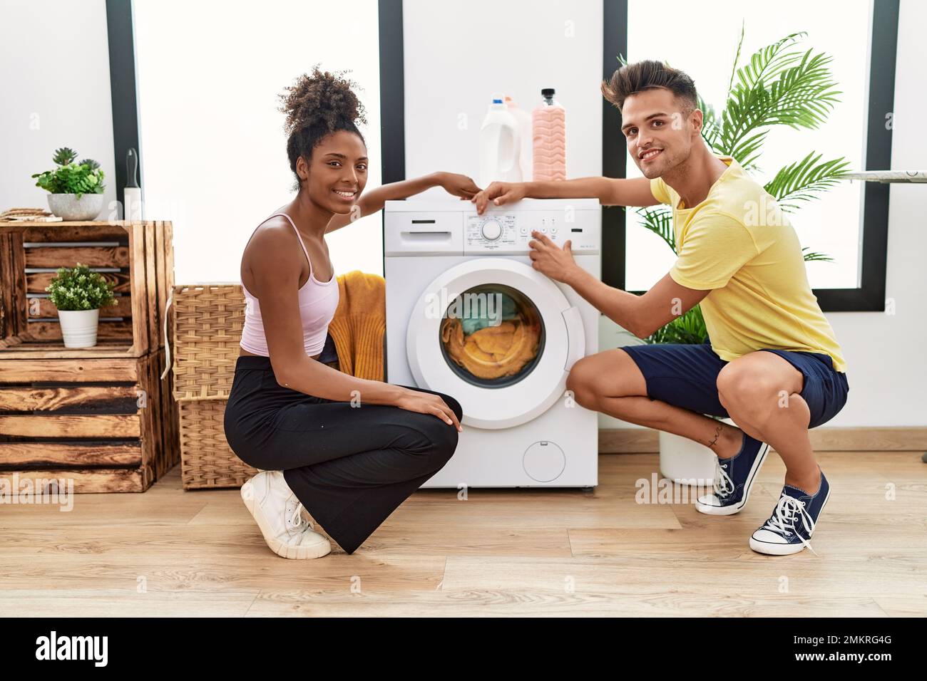 Man and woman couple smiling confident turn on washing machine at laundry room Stock Photo - Alamy