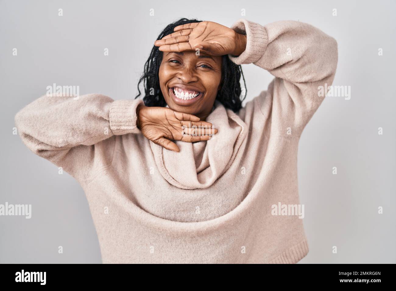 African woman standing over white background smiling cheerful playing ...