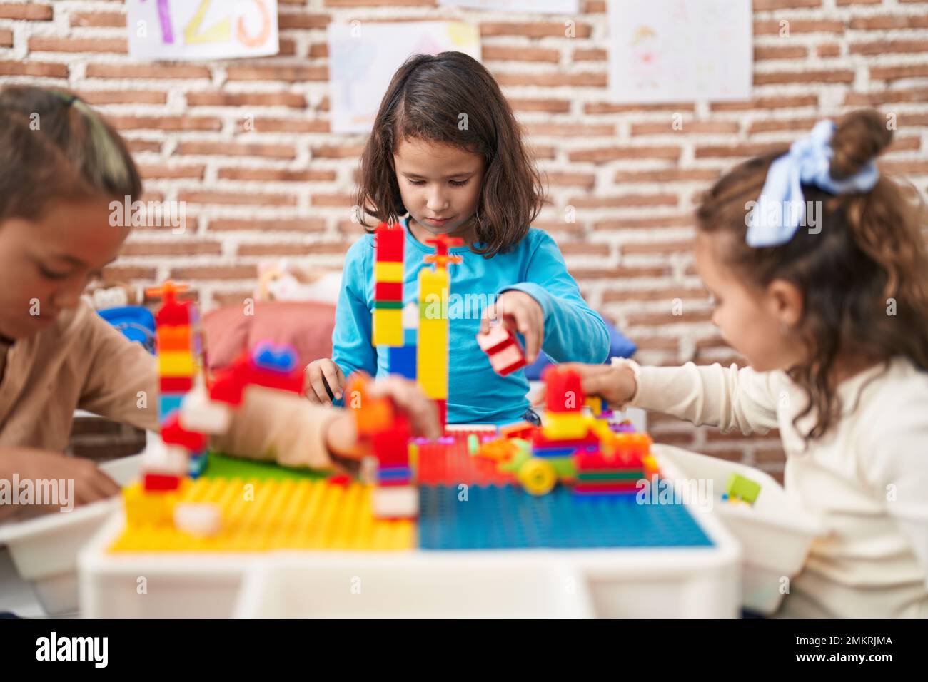Group of kids playing with construction blocks sitting on table at ...