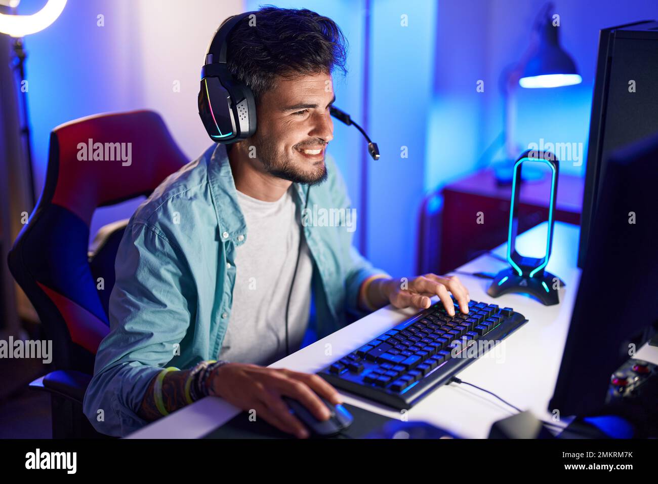 Young hispanic man streamer playing video game using computer at gaming ...
