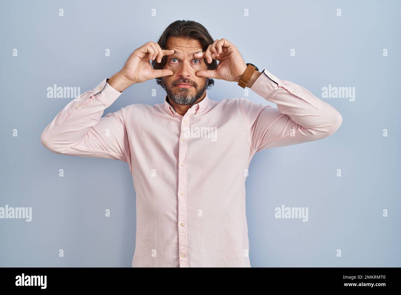 Handsome middle age man wearing elegant shirt background trying to open ...