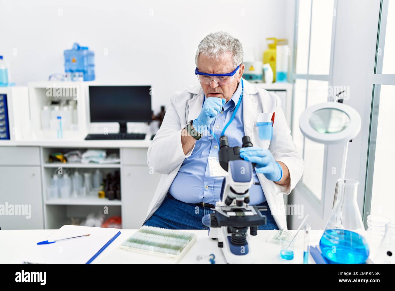 Senior caucasian man working at scientist laboratory feeling unwell and ...