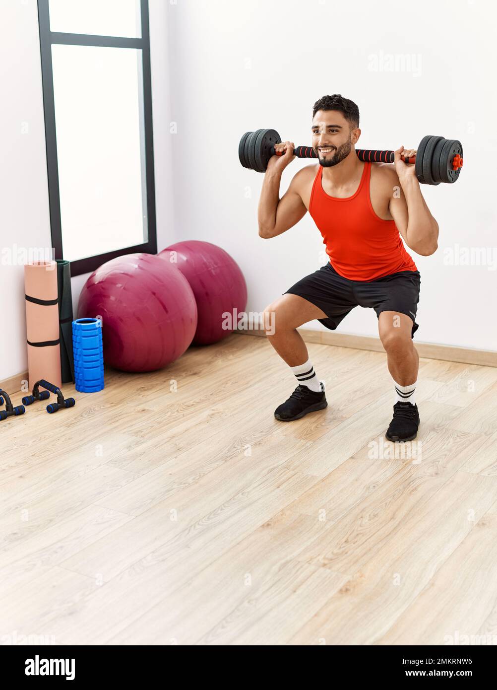 Young arab man smiling confident training with dumbbells at sport ...