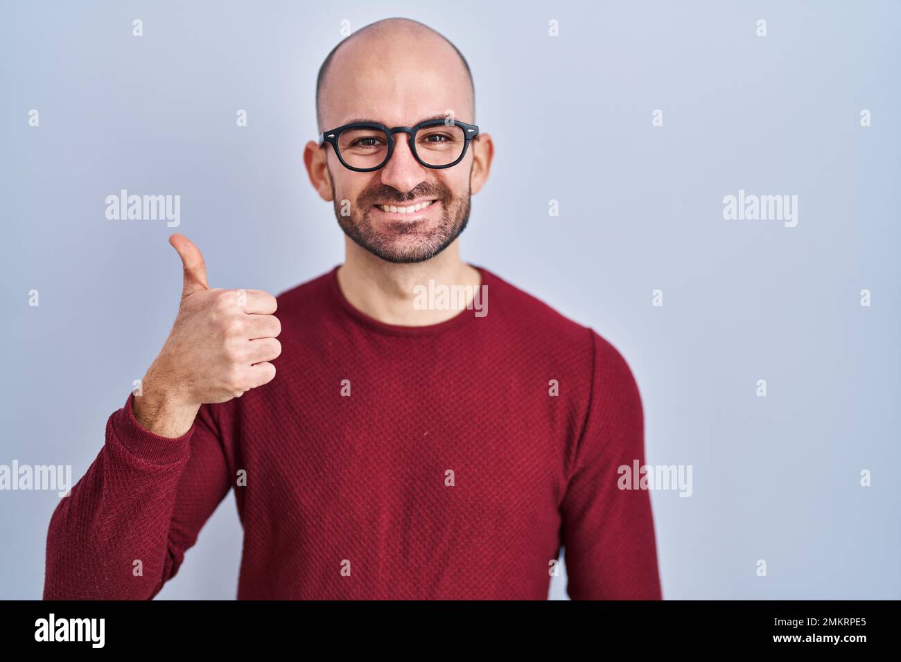 Young bald man with beard standing over white background wearing ...