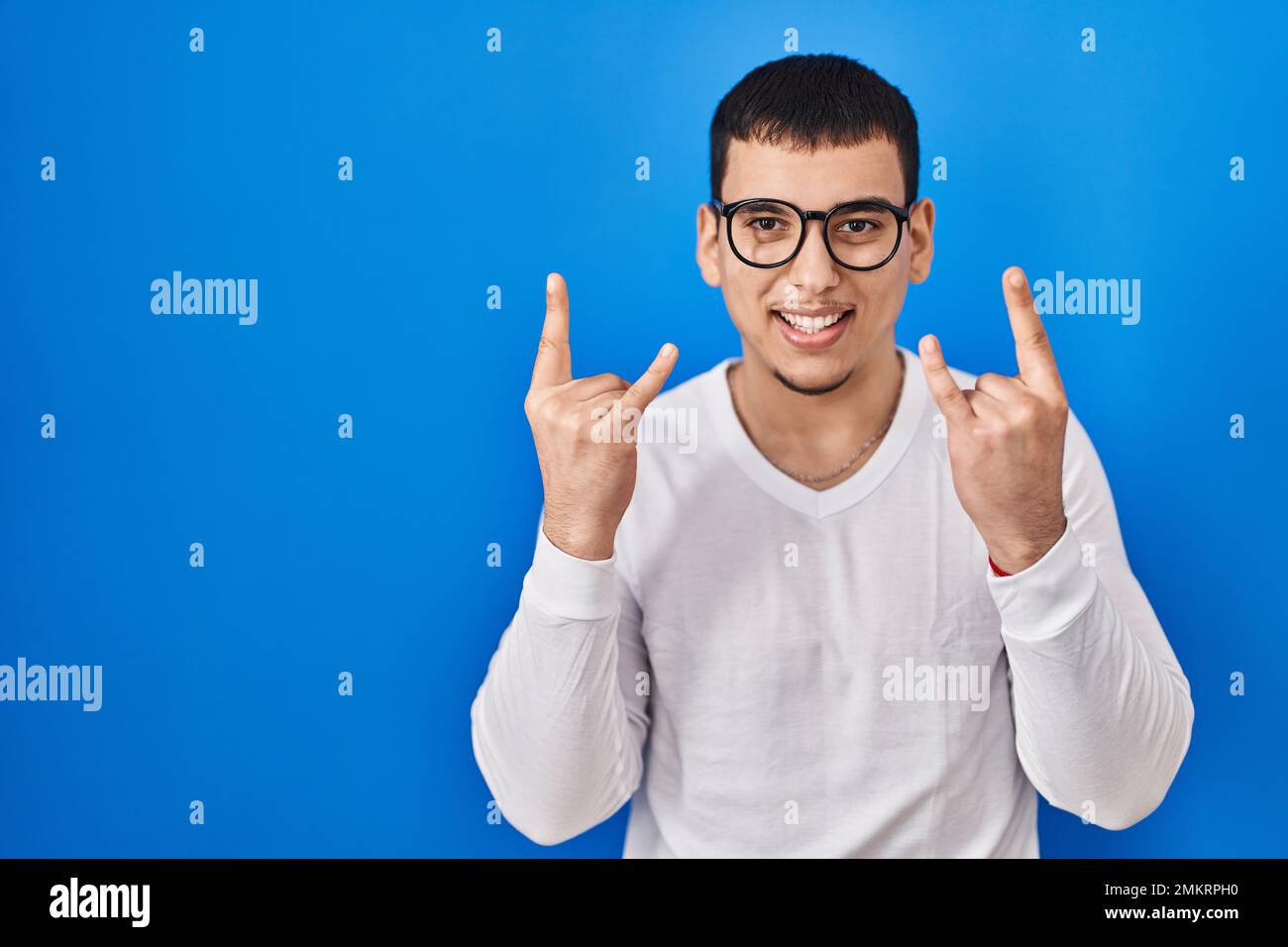 Young Arab Man Wearing Casual White Shirt And Glasses Shouting With