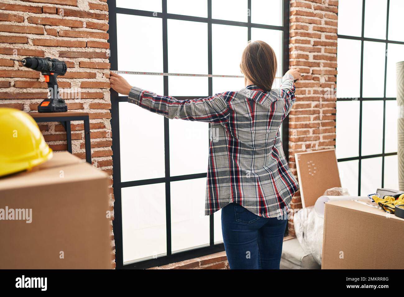 Young blonde woman measuring window at new home Stock Photo - Alamy