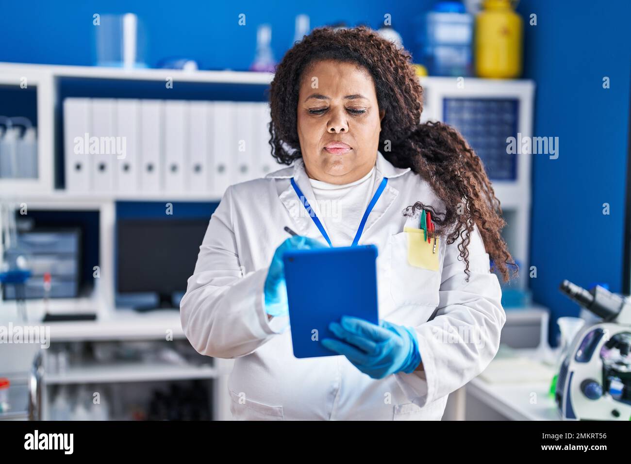 African american woman scientist writing on touchpad at laboratory Stock Photo - Alamy