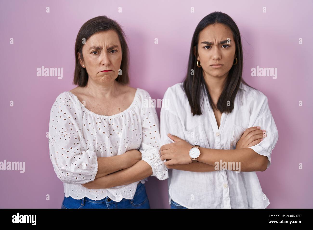 Hispanic mother and daughter together skeptic and nervous, disapproving ...