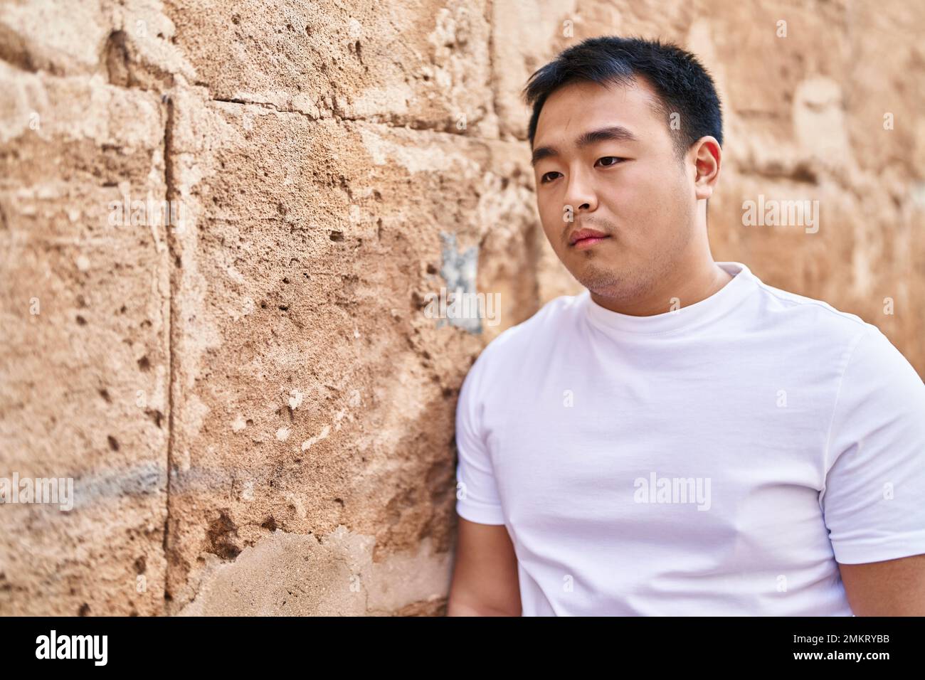 Young chinese man standing with relaxed expression at street Stock ...