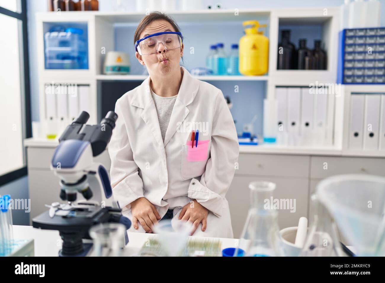 Hispanic girl with down syndrome working at scientist laboratory making ...