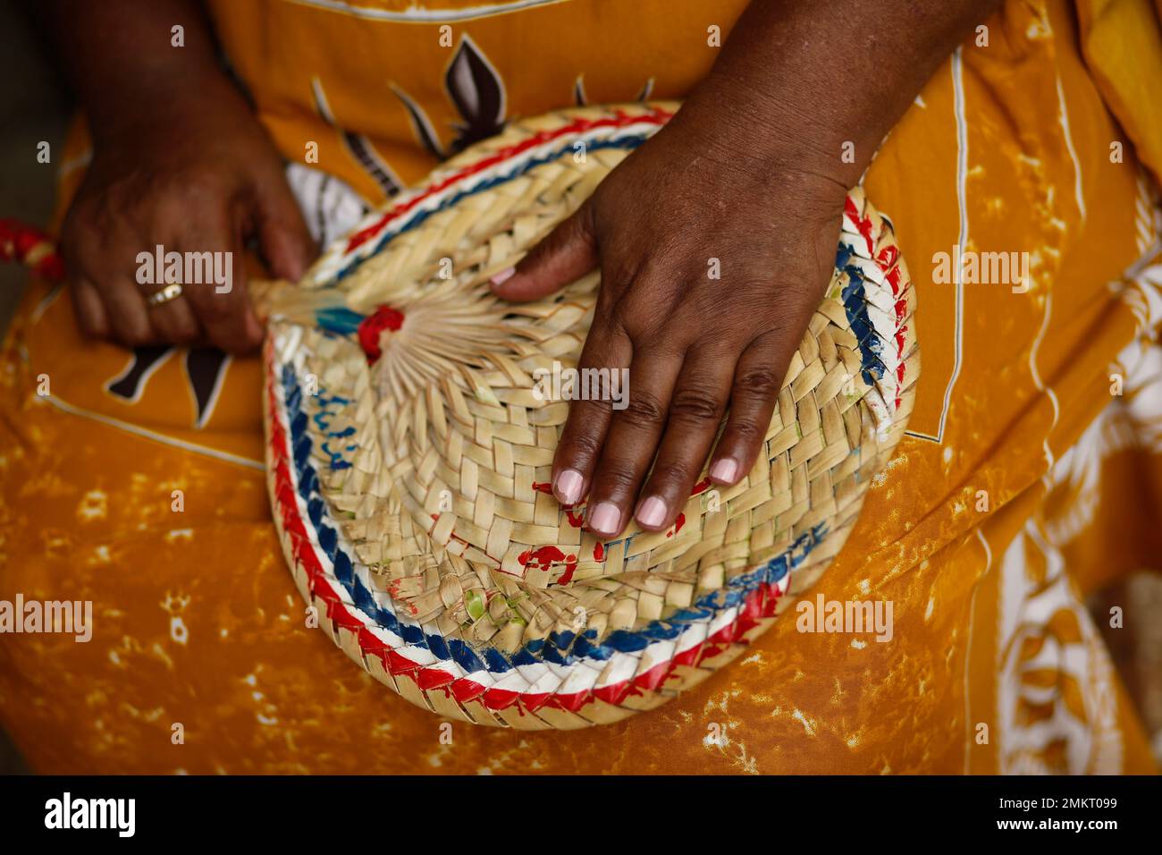 Julia Elena Chavez Medina holds a hand fan made of palm fronds as she ...