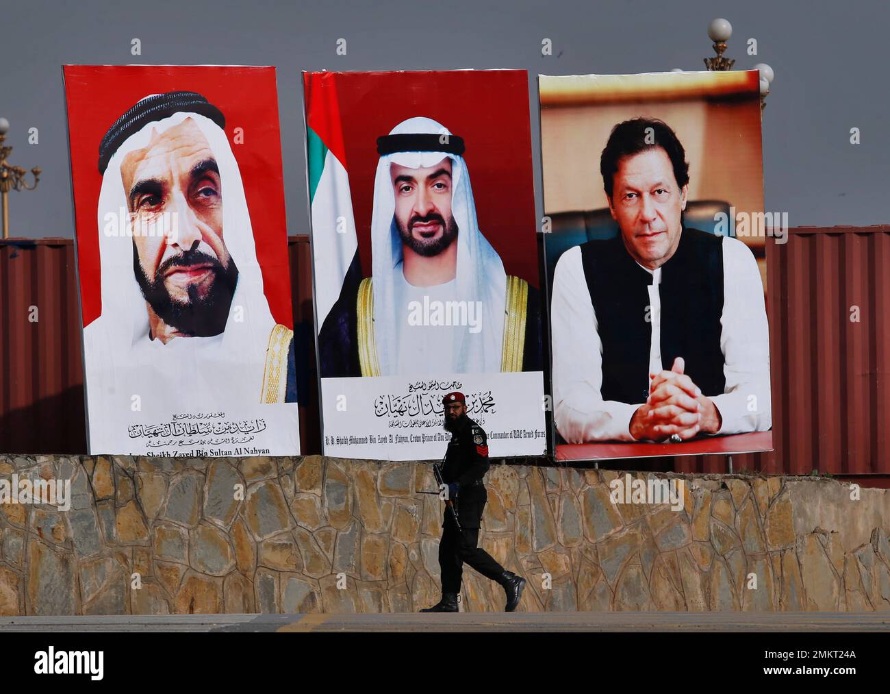 A police commando walks past the huge billboards showing the portraits ...