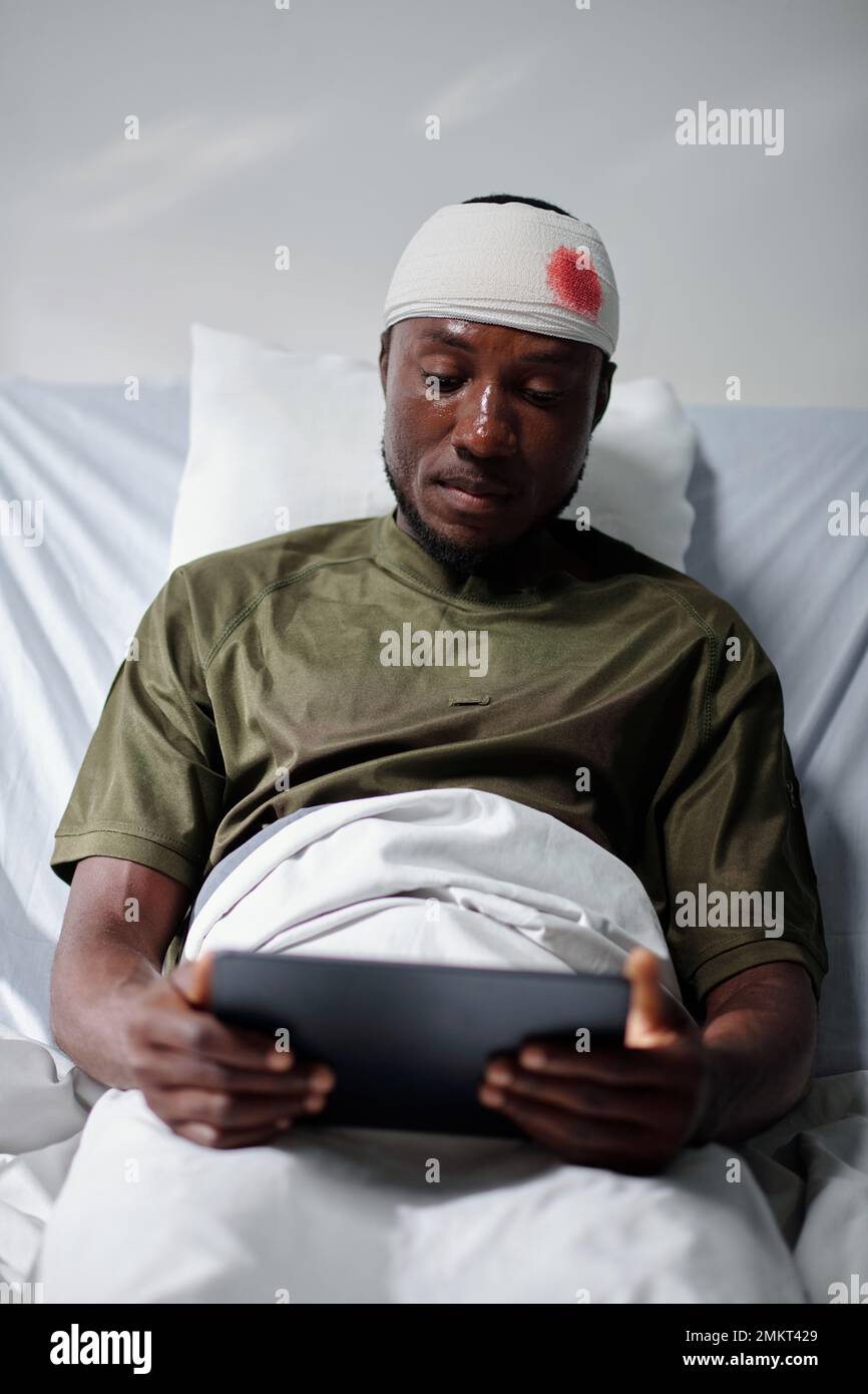 Military man with head injury watching video on tablet computer Stock ...