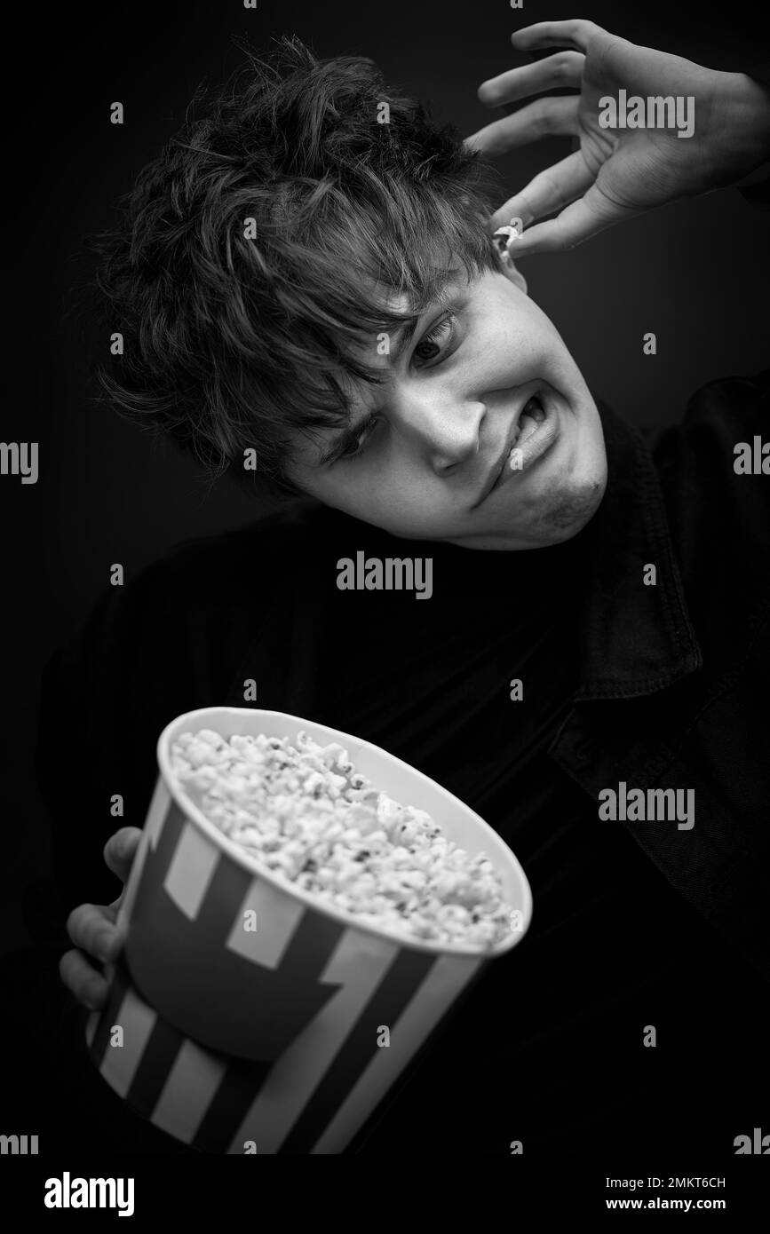 portrait of crazy young man holding bucket of popcorn Stock Photo - Alamy