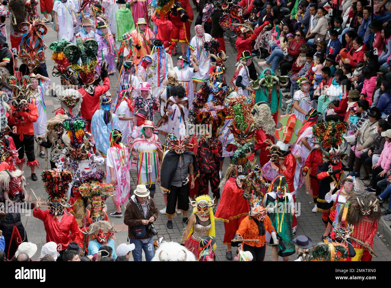 Revelers wearing colorful masks dance in the streets of Pillaro ...