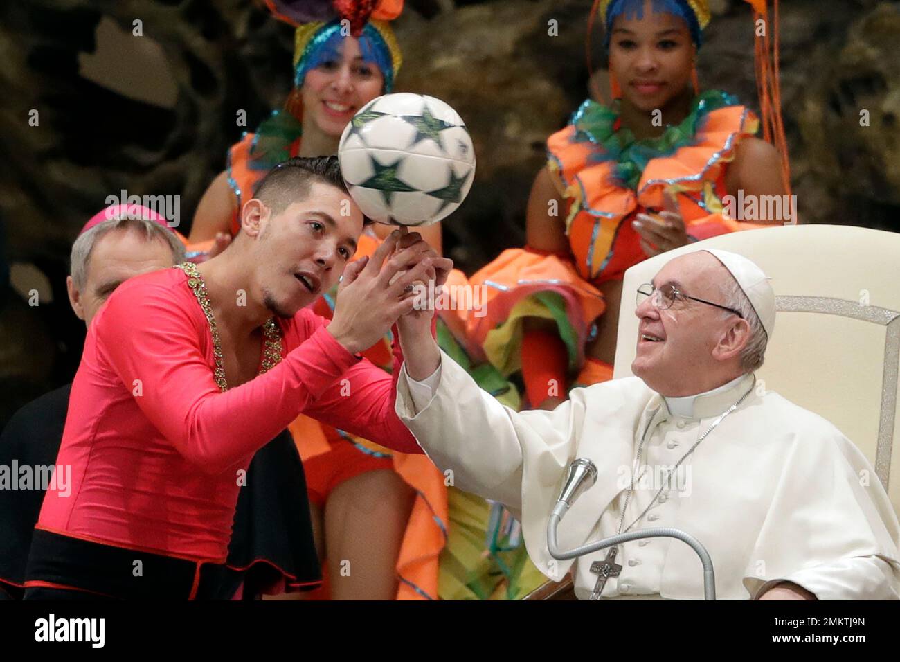 Pope Francis is shown how to twirl a soccer ball by a member of the ...