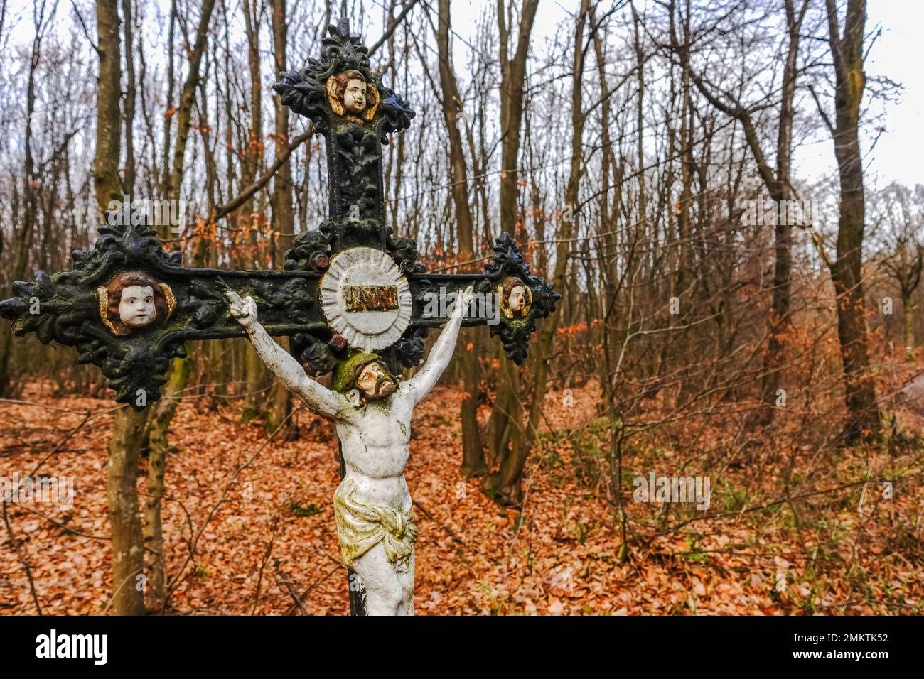 cross with jesus at a place in the forest during hiking in the winter ...