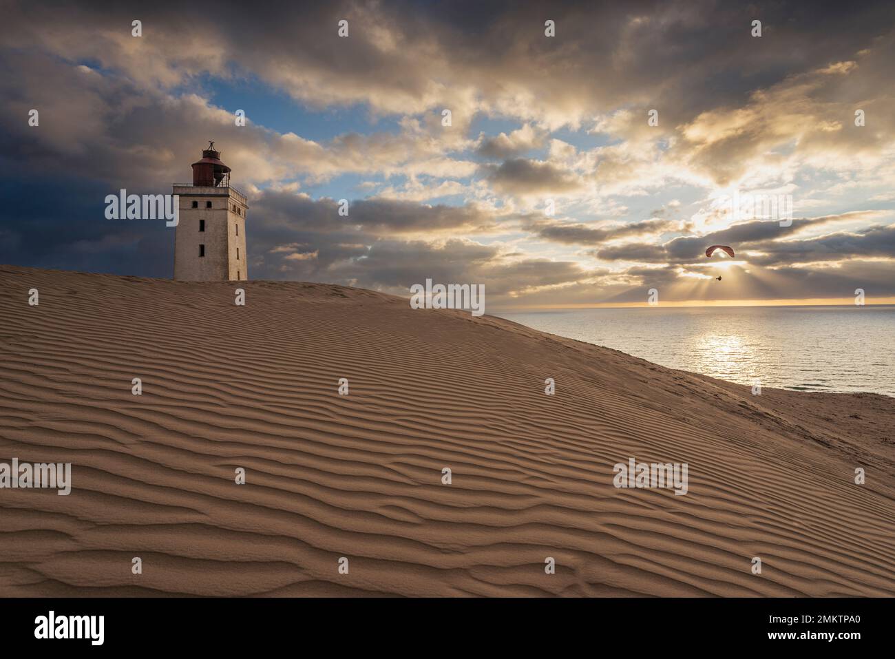Paragliders in the sunset at Rubjerg Knude Fyr lighthouse on Rubjerg ...
