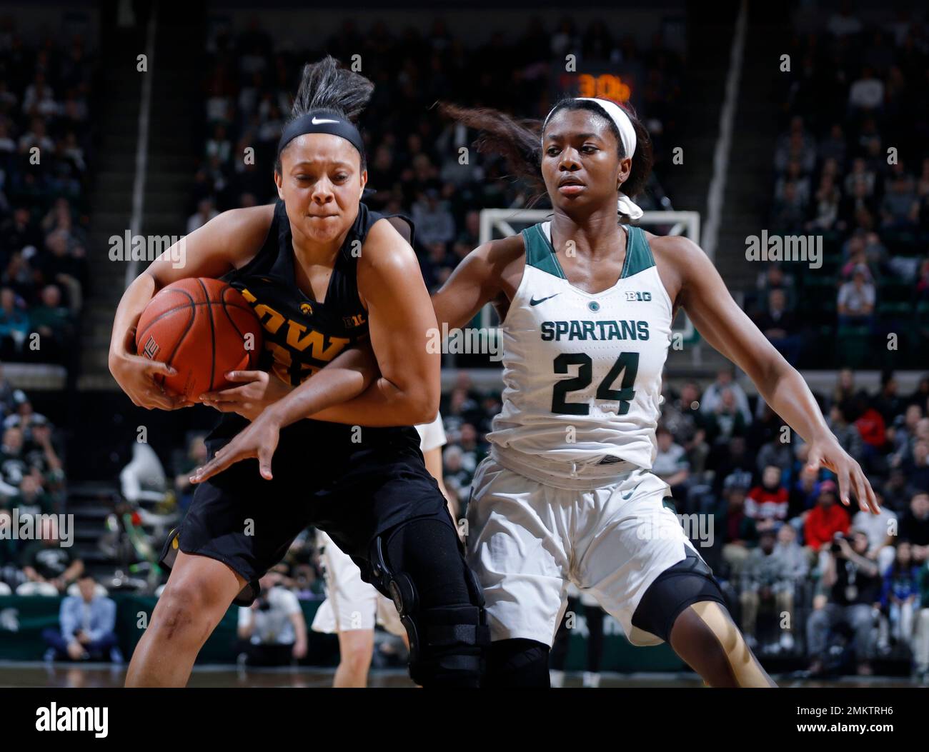 Iowa's Tania Davis, left, and Michigan State's Nia Clouden (24) vie for ...