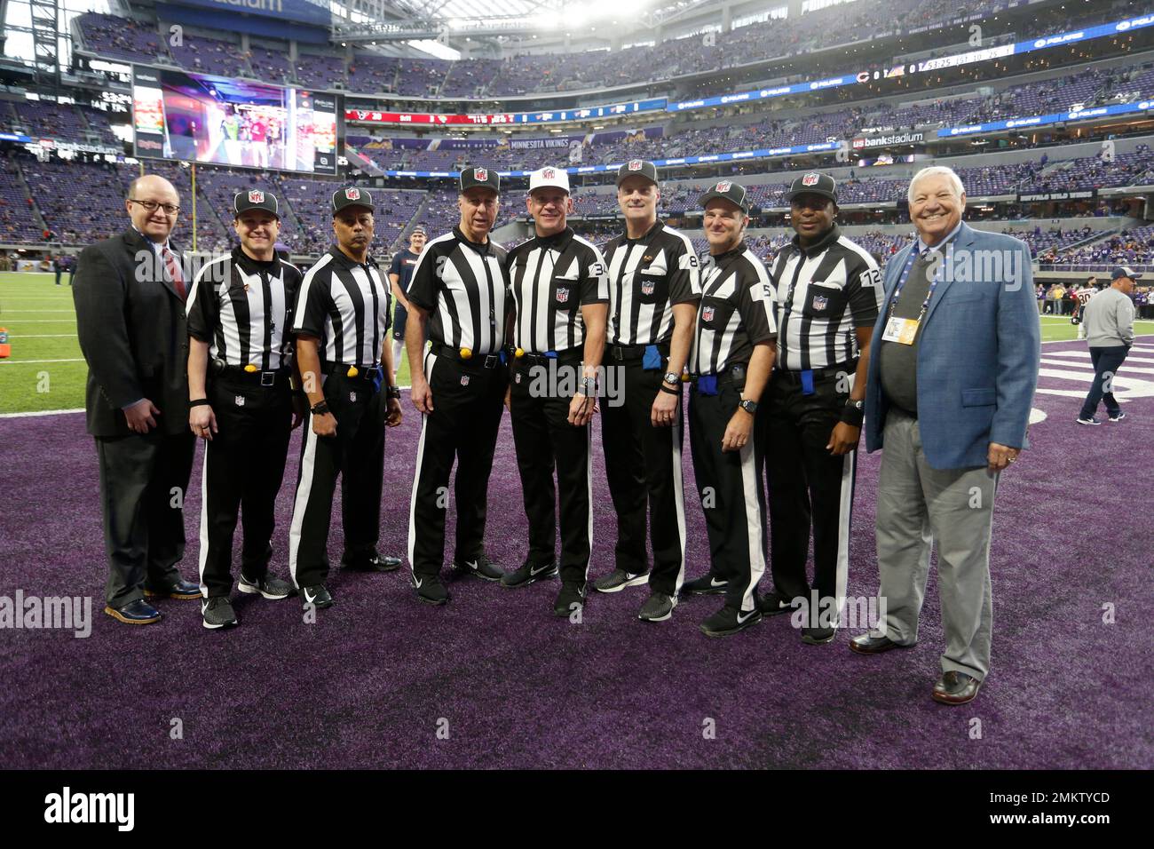 Game officials pose on the field before an NFL football game between ...
