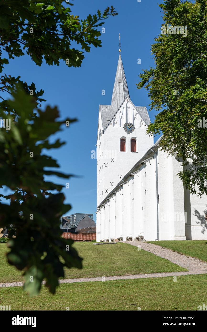 The white cathedral of Thisted shines brightly against a blue cloudless ...