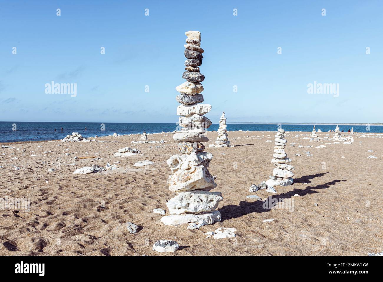 Cairns of flint stones standing on the sandy beach of Klitmöller on the ...