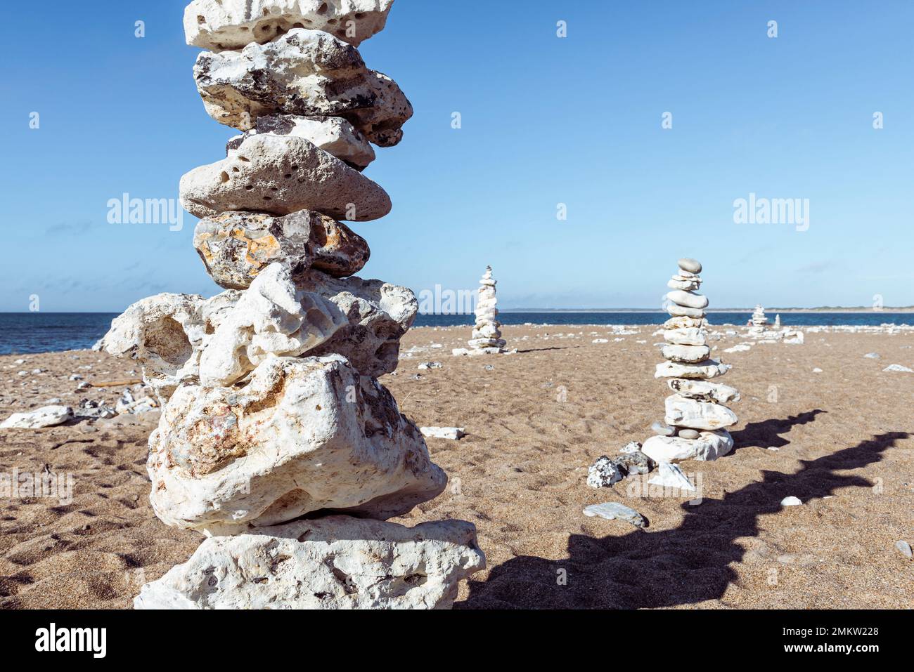 Cairns of flint stones standing on the sandy beach of Klitmöller on the ...