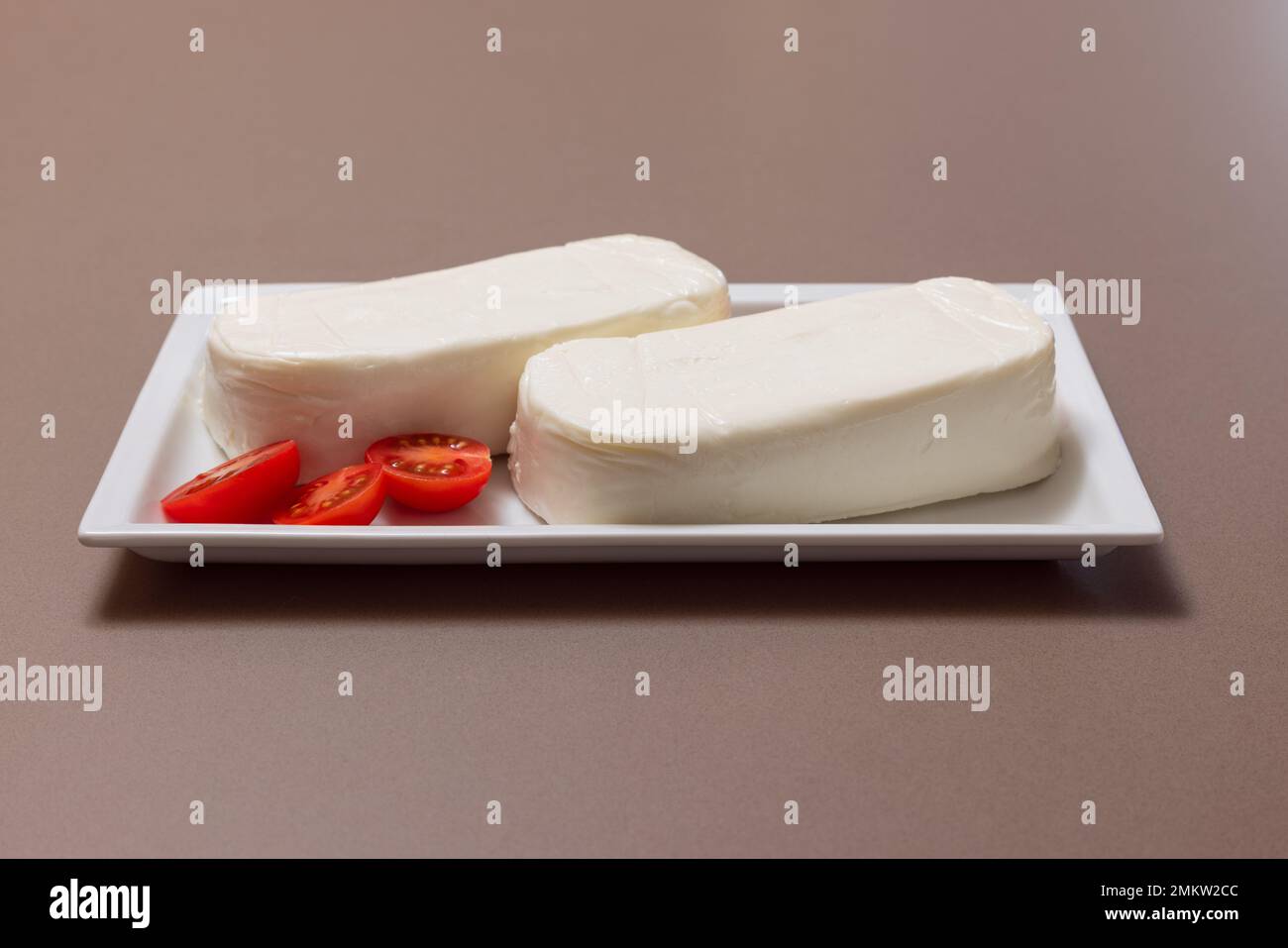 Italian mozzarella cheese for pizza on a white rectangular plate ...