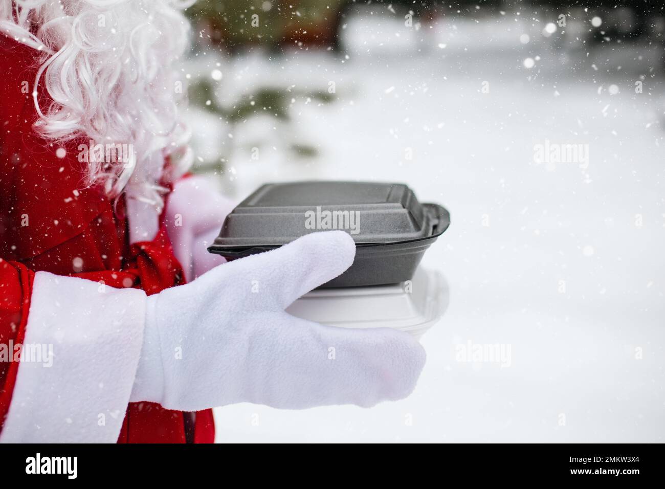 Food delivery service containers in hands of Santa Claus outdoor in ...