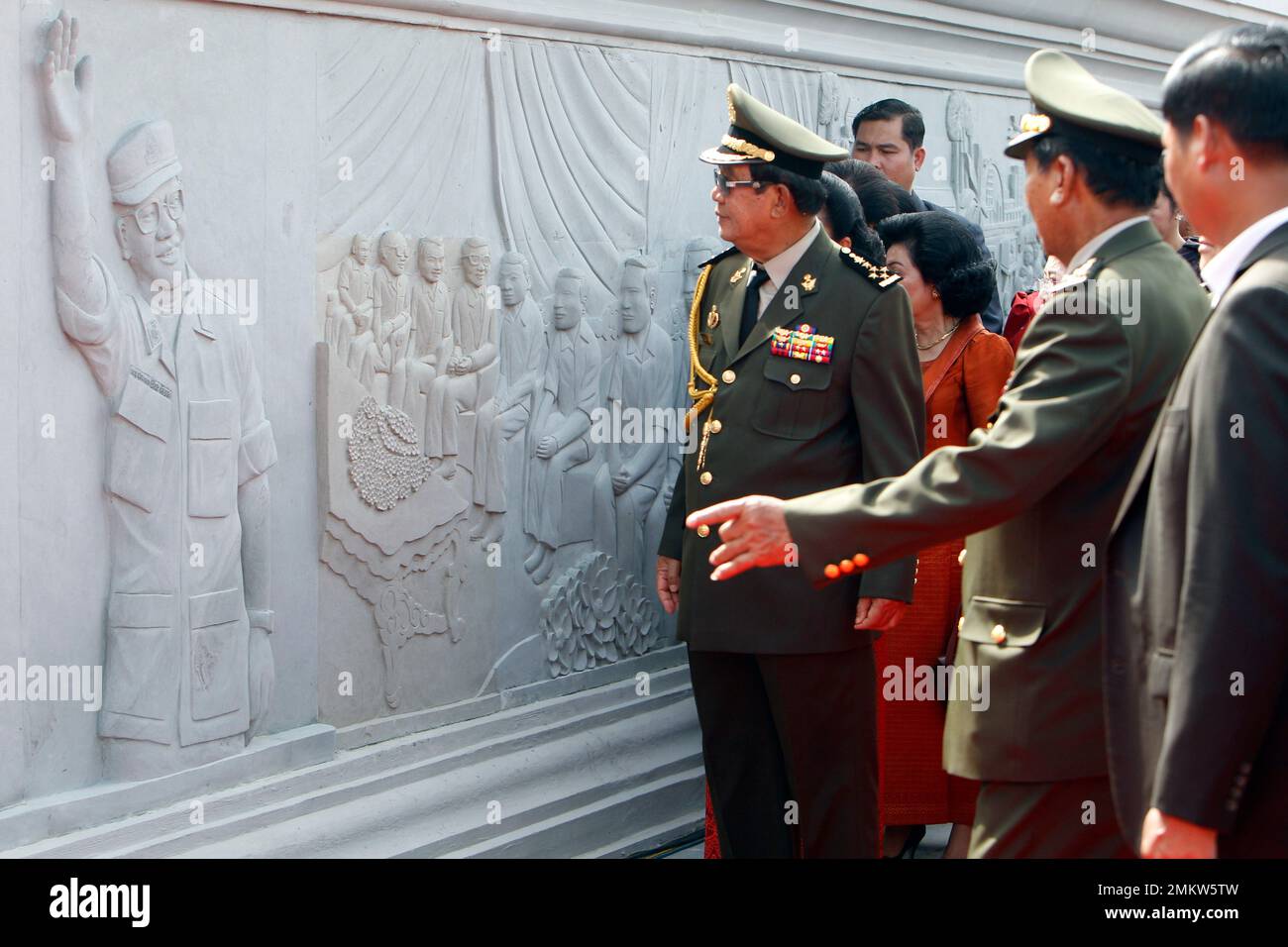 Cambodia's Prime Minister Hun Sen, center, views a relief of himself on ...