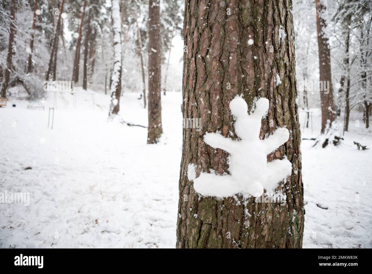 A snowman in the shape of a hare is stuck on the trunk of a tree. Fun ...