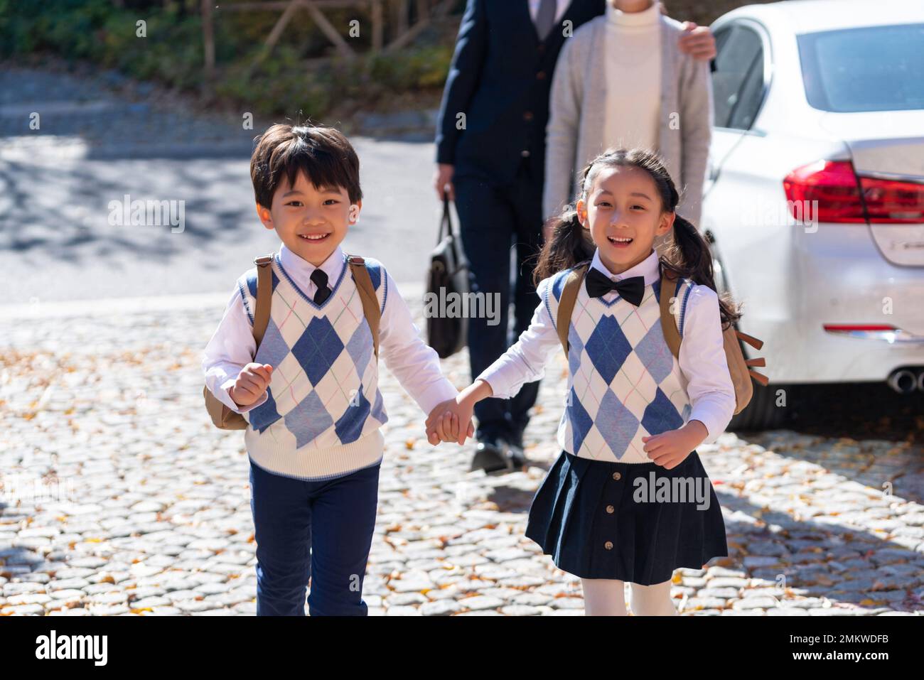 A young couple pick up the kids from school Stock Photo - Alamy