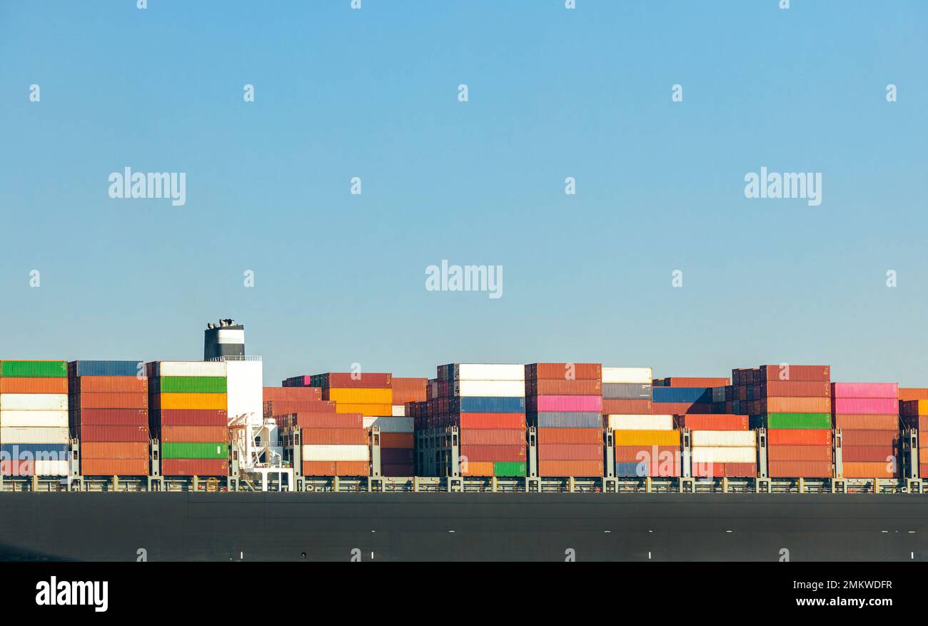Large cargo container ship loaded with containers against the blue sky ...