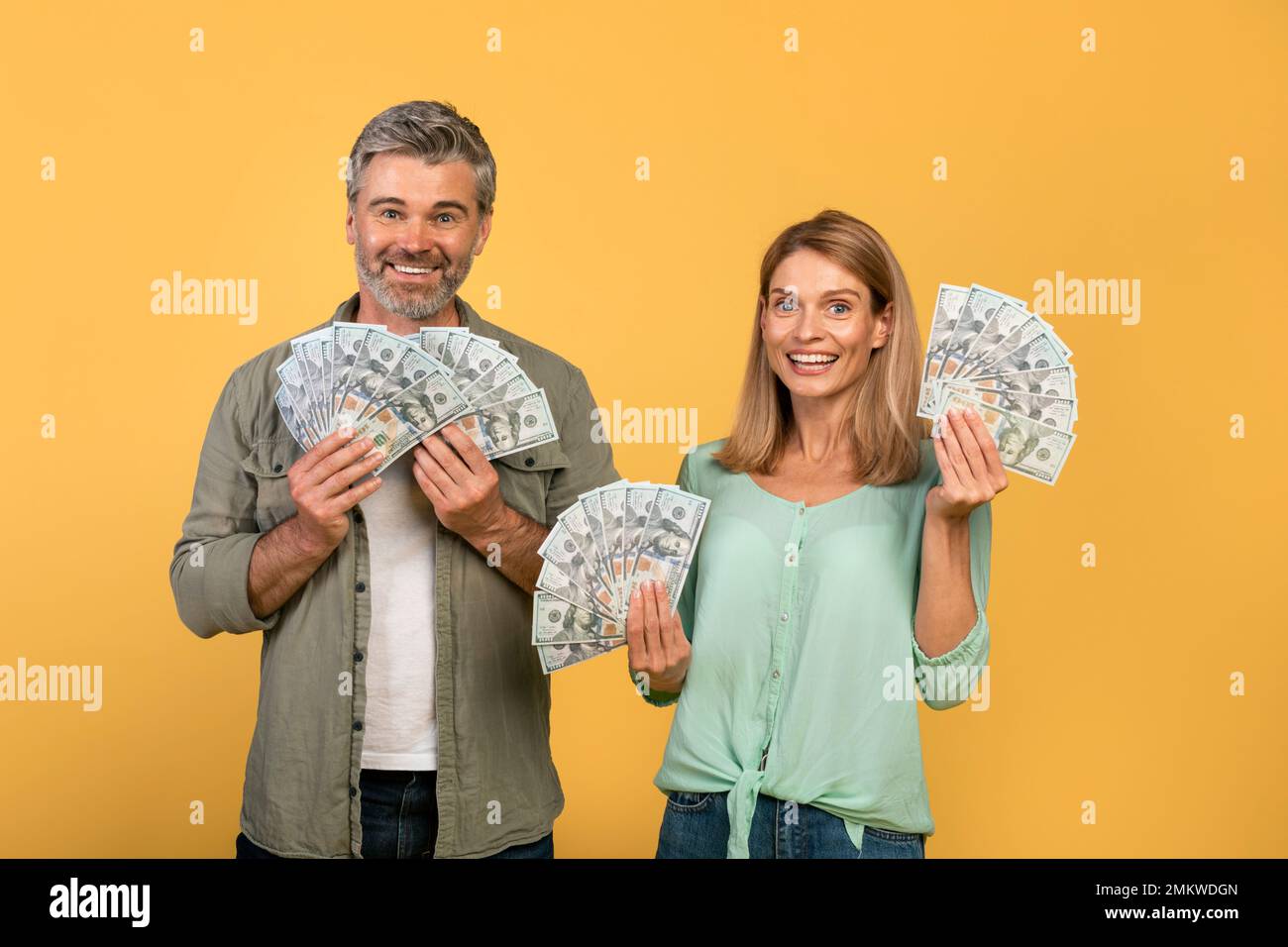 Big luck and win concept. Excited middle aged spouses holding a lot of ...