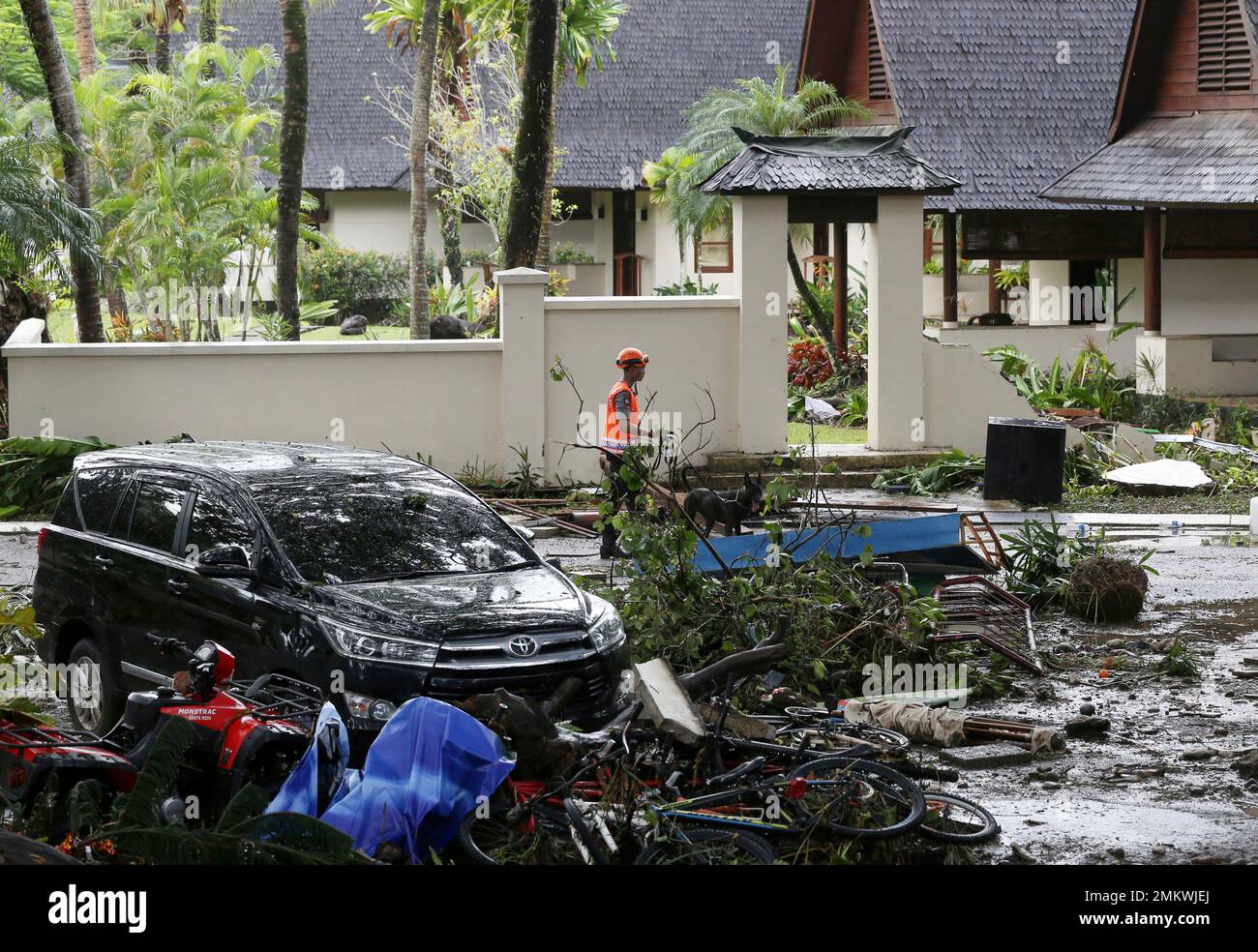 A police officer carries his K9 unit search dog as they continue to ...