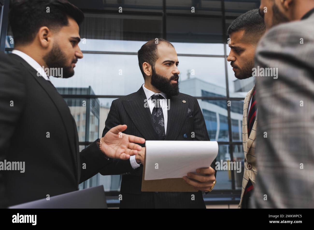 Business people outdoor meeting. Men in jackets discuss working moments ...