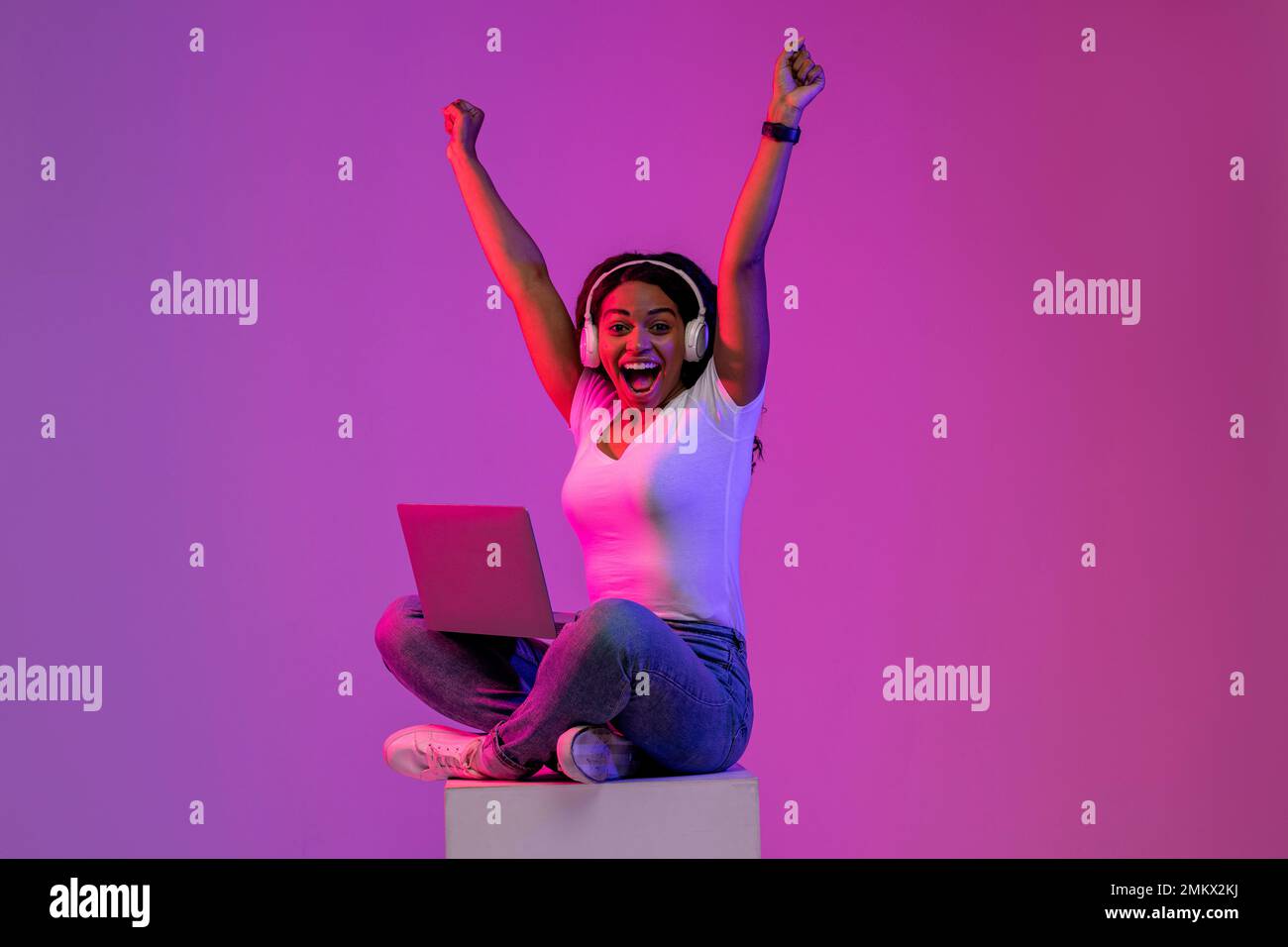 Excited Black Woman In Headphones Celebrating Success With Laptop In ...