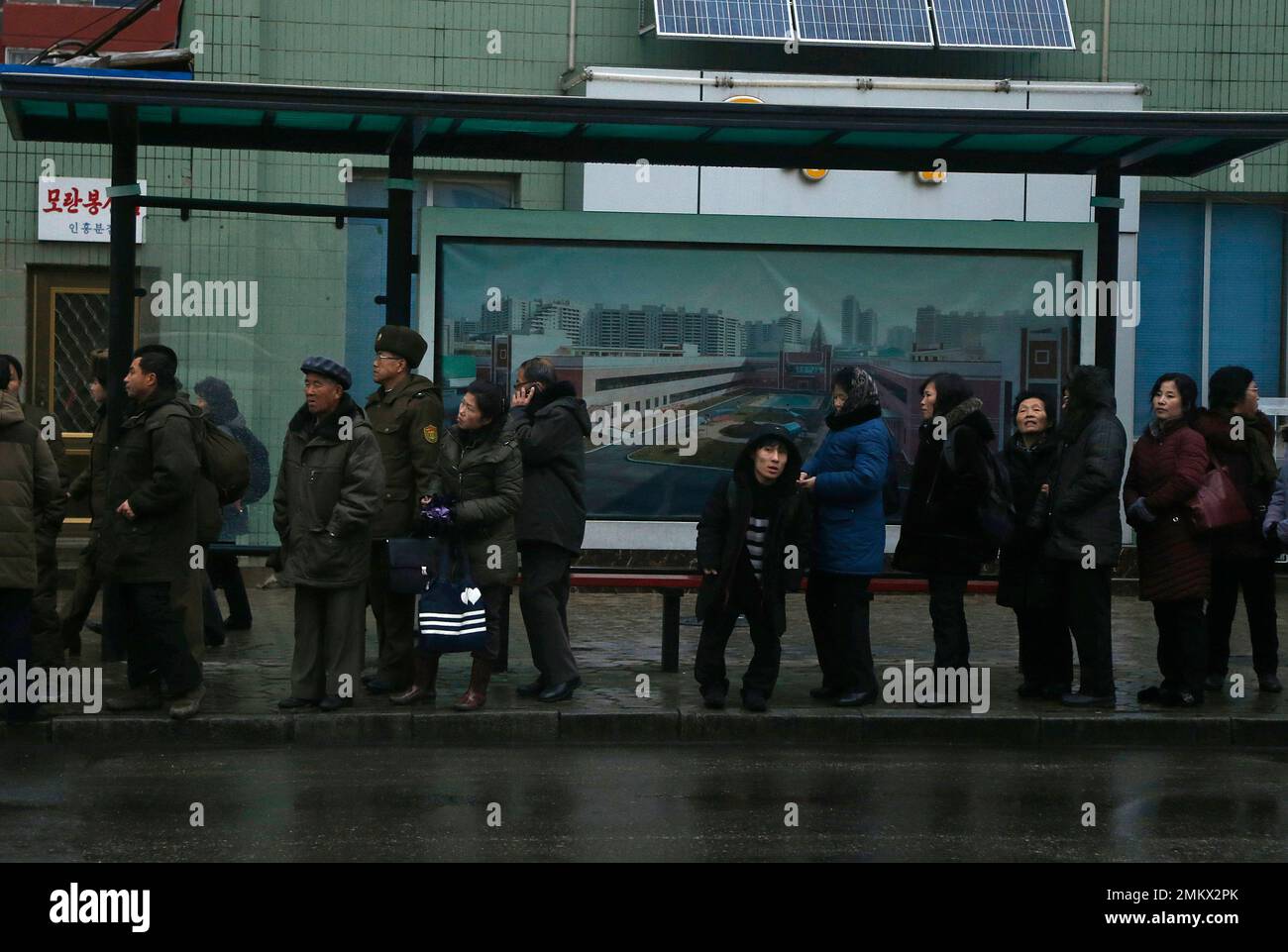 People wait for their bus at a bus stop in downtown Pyongyang, North ...