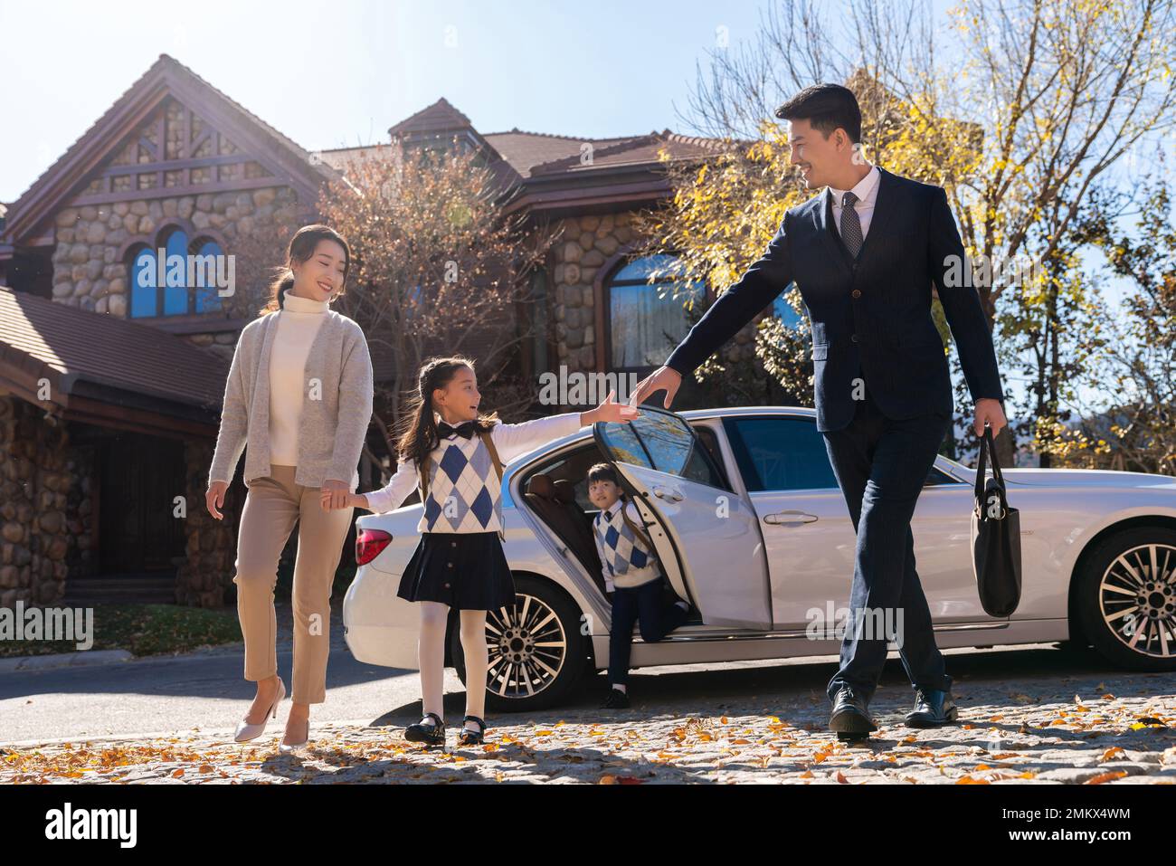 A young couple pick up the kids from school Stock Photo - Alamy
