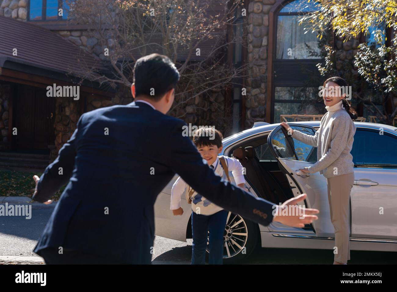 A young couple pick up the kids from school Stock Photo - Alamy