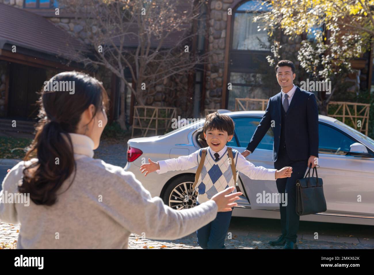 A young couple pick up the kids from school Stock Photo - Alamy