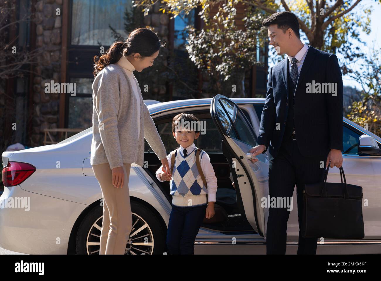 A young couple pick up the kids from school Stock Photo - Alamy