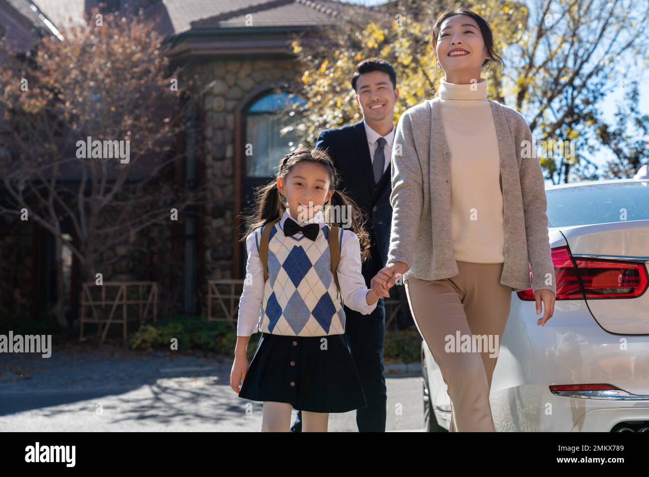 A young couple pick up the kids from school Stock Photo - Alamy