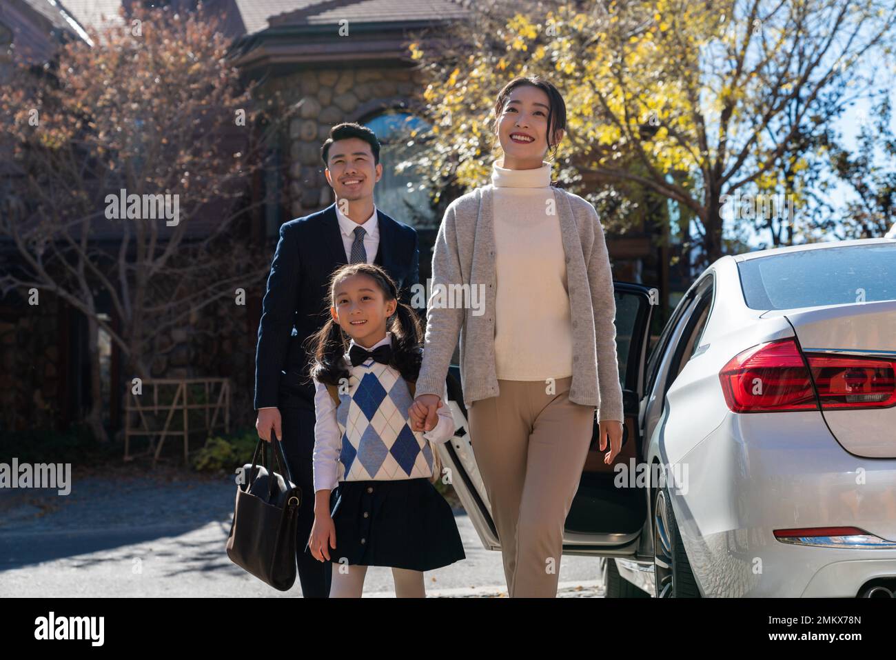 A young couple pick up the kids from school Stock Photo - Alamy