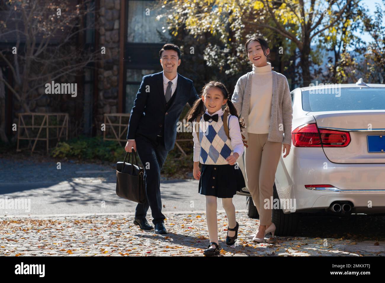 A young couple pick up the kids from school Stock Photo - Alamy